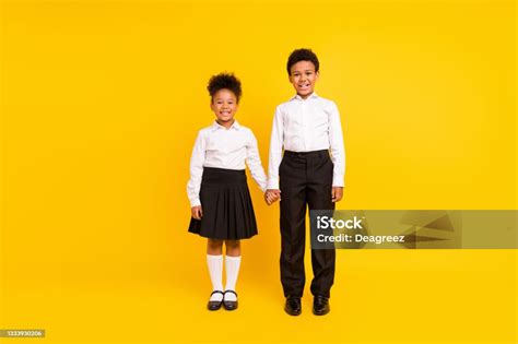 행복한 쾌활한 젊은 아프로 미국 아이들의 전체 길이 사진은 노란 색 배경에 고립 된 손 미소를 잡고 교복에 대한 스톡 사진 및 기타 이미지 Istock