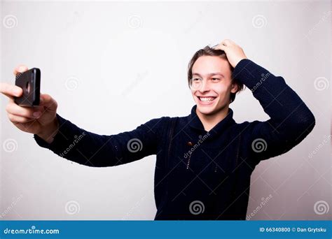 Счастливый молодой человек принимая фотографию автопортрета через умный телефон Стоковое Фото