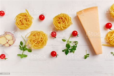 파스타 를 요리하기위한 재료 타글리아텔 토마토 마늘 바질 흰색 나무 배경 평면 평지에 파마산 치즈 상단 보기 프레임 복사 공간 이탈리아 음식 개념 건강관리와 의술에 대한