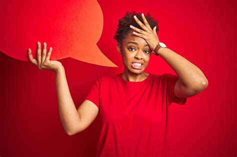 빨간 고립 된 배경 위에 연설 거품을 들고 젊은 아프리카 계 미국인 여성은 부끄러움과 깜짝 얼굴 분노와 좌절에 충격 머리에 손으로 스트레스 실수에 대한 두려움과 화가 감정에