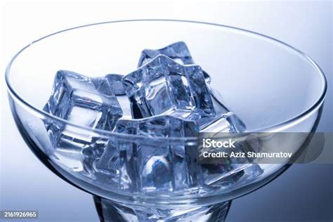 시원한 파란색 배경에 투명한 유리 그릇에 담긴 수정처럼 맑은 얼음 조각을 클로즈업하여 얼음의 순수함과 상쾌한 품질을 보여줍니다 물에 대한 스톡 사진 및 기타 이미지 Istock