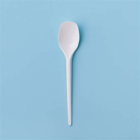 파란색 배경에 플라스틱 숟가락 프리미엄 사진
