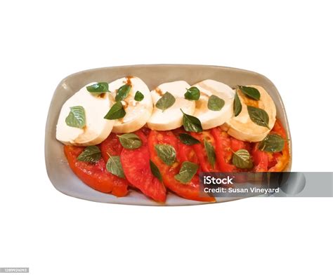 얇게 썬 토마토와 모짜렐라 치즈 라운드의 분리된 카프리세 샐러드는 발사믹 식초를 뿌렸고 바질 잎을 뿌렸습니다 0명에 대한 스톡 사진 및 기타 이미지 Istock