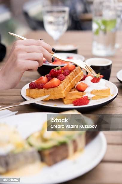 여름 카페에서 달콤한 아침 식사 나무 테이블에는 아이스크림 및 딸기와 라즈베리 과일 열매의 특 종을 가진 디저트 와플 황금 칼