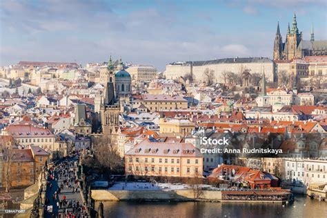2017년 12월 18일 체코 프라하 프라하 체코 눈이 붉은 타일 지붕에 놓여 있는 겨울 화창한 날 올드 타운 브리지 타워 카를로프 또는 찰스 다리 블타바 강에서 펼쳐지는