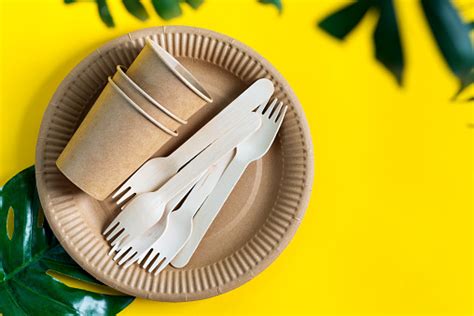 녹색 열대 잎이있는 노란색 배경에 종이와 나무로 만든 친환경 일회용 식기 세트 맨 위 보기입니다 갈색에 대한 스톡 사진 및 기타 이미지 Istock