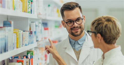 약장 근처에 서서 선배 동료와 함께 일하는 행복한 젊은 남성 약사 사진 Unsplash의 약사 이미지