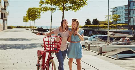 여름에 자전거를 타고 도시를 걷고 있는 동안 함께 웃고 있는 두 젊은 가장 친한 친구 사진 Unsplash의 도시 이미지