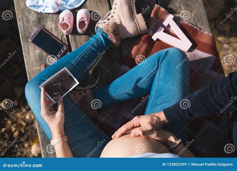 Top View Of Beautiful Pregnant And Her Husband Touching The Tummy And