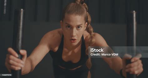 썰매 밀기 여성 및 체육관 운동 피트니스 및 힘 및 근육 에너지를위한 운동 및 훈련 헬스 클럽에서 중장비 웨이트에 대한 집중력 강하고 건강한 여성 보디빌더 선수 도전 결심에