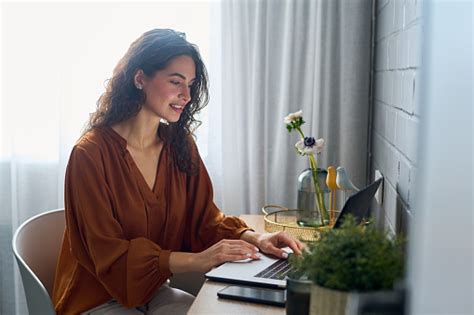 홈 오피스에서 네트워크 동안 노트북 화면을 보는 블라우스의 예쁜 소녀 컴퓨터에 대한 스톡 사진 및 기타 이미지 컴퓨터 베이지 비즈니스 Istock