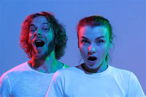 네온 빛으로 푸른 배경 위에 고립 된 포즈를 취하는 젊은 남녀의 초상화 충격받은 감정 20 24세에 대한 스톡 사진 및 기타 이미지 20 24세 25 29세 2명