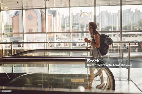 에스컬레이터에서 공항에서 모자를 쓰고 웃는 모습 기내 수하물을 가지고 여행하는 사람들 테마 관광 및 교통 에스컬레이터에 공항