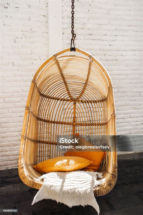 로프트 카페에서 고리버들 등나무 매달려 의자 환경 친화적 인 가구 스타일과 개념 오렌지 베개와 의자에 부드러운 모피 힙스터 카페 가구에 대한 스톡 사진 및 기타 이미지