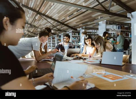Multiracial Male And Female University Babes Doing Assignment In Library Stock Photo Alamy