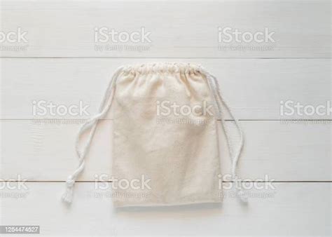 캔버스 가방 드로스트링 천연 면 직물 천으로 만든 작은 에코 자루의 모형은 상단보기에서 흰색 나무 배경에 누워 토트백에 대한 스톡 사진 및 기타 이미지 Istock