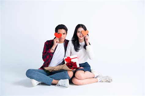 집에서 아름 다운 젊은 부부 포옹 키스와 함께 시간을 보내는 동안 함께 세인트 발렌타인 데이를 축 하 하는 동안 손에 선물 상자와 공기 풍선 배경에 마음의 모양 커플에 대한