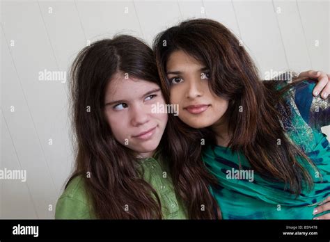 Young Indian Woman And Her Preteen Caucasian Stepsister Posing Together