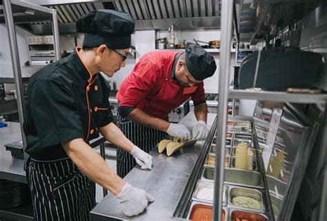 아시아 중국 남성 연수생 주방 승무원이 상업용 주방에서 타코 멕시코 음식을 준비하는 마스터 셰프로부터 배우기 교육 강좌에 대한