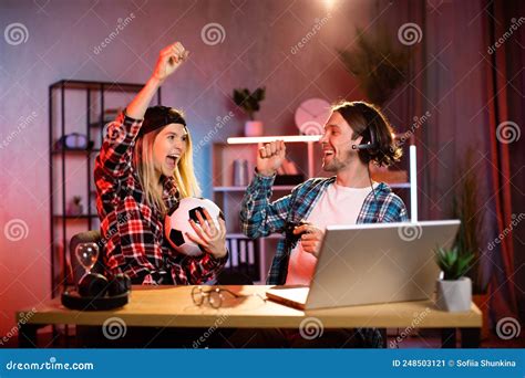 позитивная молодая пара дала пять сидя за столом и смотря футбол Стоковое Изображение