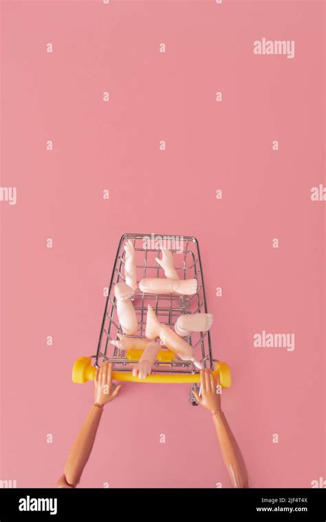 Puppet Hands Pushing A Trolley From A Supermarket On A Pink Background
