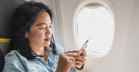 비행기의 창가 좌석에 앉아 이륙하기 전에 휴대 전화에서 비행기 모드를 켠 아시아 여성 사진 Unsplash의 좌석 이미지