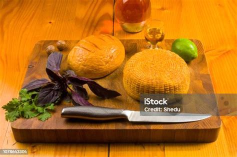 국가 Adyghe 치즈 칼 바 질 파 슬 리 석 회 참기름 칠리 페 퍼 마 카 다 미아 너트와 나무 테이블에 디 켄 터와 절삭 보드에 만든 클로즈업 갈색에 대한 스톡 사진