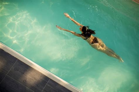 Mulher De Biquíni Flutuando Na água Na Piscina No Dia De Verão Foto Premium