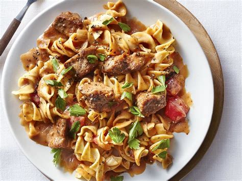 A White Plate Topped With Pasta And Meat