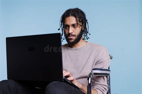 Focused Programmer In Wheelchair Developing Software On Laptop Stock