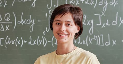 책을 들고 카메라를 향해 웃고 있는 교사의 초상화는 칠판에 기대어 서서 대학에서 가르치고 있다 사진 Unsplash의 선생 이미지