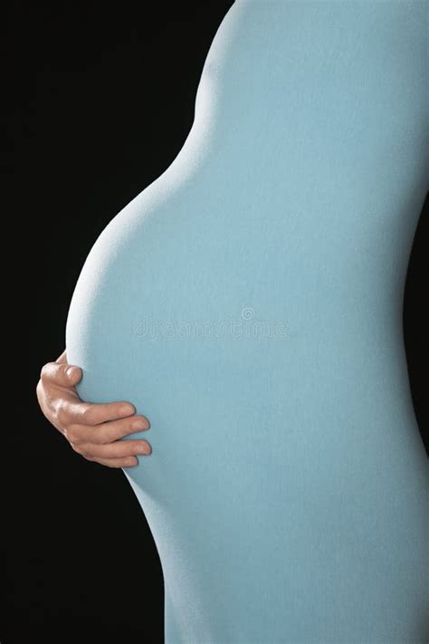 Pregnant Woman In Body Suit Holding Abdomen Mid Section Side View