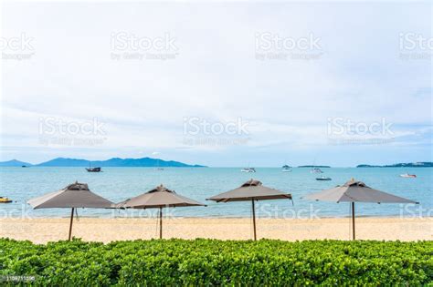 푸른 하늘과 흰색 구름에 코코넛 야자수와 우산과 의자가있는 아름다운 열대 해변 바다와 바다 0명에 대한 스톡 사진 및 기타