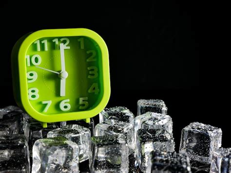 Premium Photo Close Up Of Clock Over Ice Cubes Against Black Background