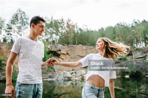 젊은 부부는 호수 근처가는 남자와 여자 바위와 돌의 배경에가 오래 된 산업 화강암 채 석 장의 풍경입니다 닫습니다 절반 길이 위쪽 절반 2명에 대한 스톡 사진 및 기타