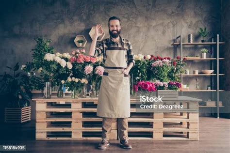 그의 전체 길이 몸 크기보기 그의 좋은 매력적인 쾌활한 콘텐츠 남자 착용 유니폼을 입고 모란 다른 무리 판매 관리자 보여주는 Oksign 에 산업 콘크리트 스타일 살롱 실내