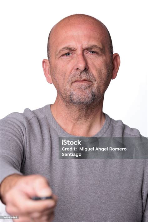 흰색 스튜디오 배경에 고립된 카메라 스튜디오 초상화를 보고 있는 50세 이상의 자신감 있는 심각한 집중된 남자 헤드샷을 닫습니다