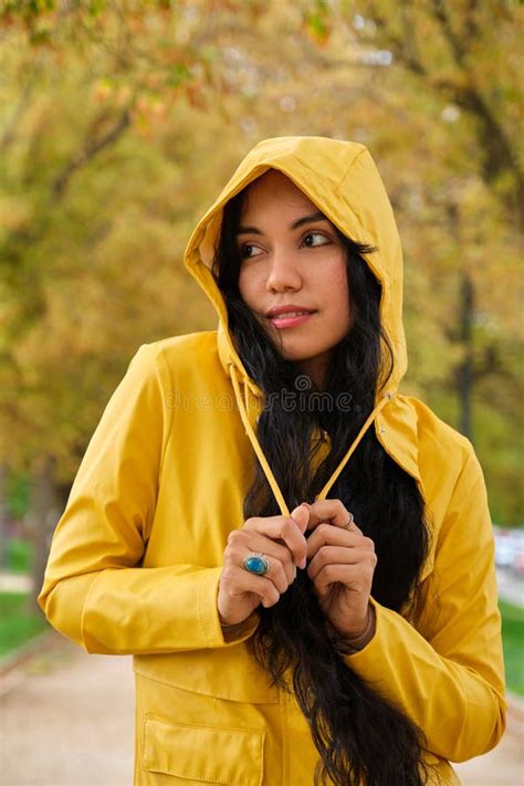 Young Latin Girl Dressed In Yellow Raincoat Posing With Hood On Her