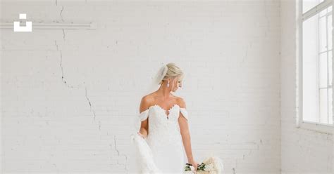 하얀 드레스를 입은 여자가 나무 바닥에 서 있다 사진 Unsplash의 무료 결혼식 이미지