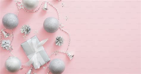 실버 크리스마스 장식 공 선물 상자 파스텔 핑크 배경에 솔방울 현대적인 고급 장식으로 크리스마스 최소한의 구성 플랫