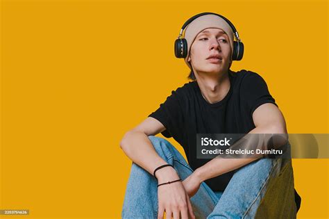 헤드폰을 끼고 생생한 노란색 배경을 배경으로 자신 있게 포즈를 취하고 있는 스타일리시한 청년 개성 개념에 대한 스톡 사진 및 기타 이미지 Istock