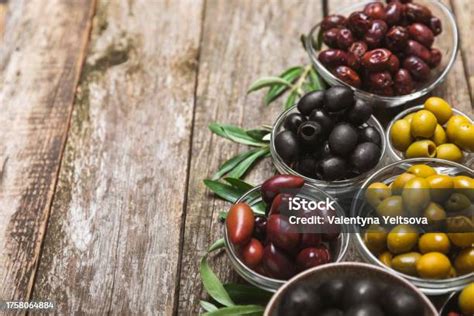 배경에 녹색 빨간색 및 검은색 올리브 세트입니다 그릇에 담긴 다양한 종류의 올리브와 신선한 올리브 잎 채식주의 올리브 과일 텍스트의 위치 공간을 복사합니다 개체 그룹에 대한