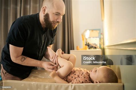 아기 위생 그리고 아이의 편부모로서 집의 보육원에서 기저귀를 갈아주는 아버지 가족 아이들 귀여운 아기를 안고 집안 청소나 보살핌을 위해 기저귀를 갈고 있는 남자 아버지에