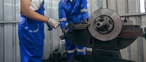 금속 선반 기계를 사용하는 정비사 또는 금속 작업자의 배경은 자동차 수리 차고에서 자동차 디스크 브레이크를 연마합니다 자동차 유지 보수 및 차량 부품 개념 검사 2명에 대한