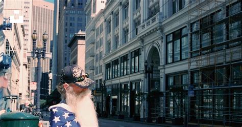 긴 흰 수염과 긴 흰 수염을 가진 남자가 성조기를 들고 있습니다 사진 Unsplash의 무료 샌프란시스코 이미지