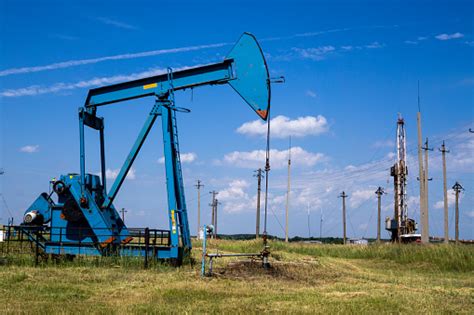 빔 펌핑 유닛은 숙제 오일 필드의 일몰입니다 석유 펌프 오일 장비 에너지 산업 기계 펌프가 우물에 설치 된 펌핑 장치 오일 분야의 장비 가솔린에 대한 스톡 사진 및 기타