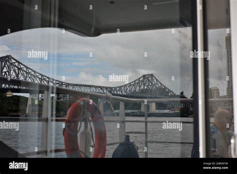 A Reflection Of The Story Bridge Seen Fin The Glass Window Of A Kitty Cat Ferry While Crossing