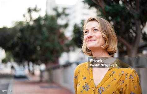 도시 보도에 서있는 동안 위를 올려다 보는 미소 짓는 젊은 여성 여자에 대한 스톡 사진 및 기타 이미지 여자 위를 보기