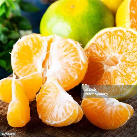 잘 익은 만다린 과일은 껍질을 벗기고 오래된 소박한 모습의 목재에 만다린 과일과 잎을 곁들인 목재를 놓습니다 겨울 과일 0명에