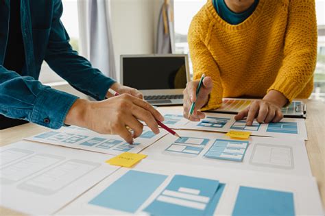 ux 개발자와 ui 디자이너가 현대 사무실에서 고객 요약 및 색상 코드와 함께 테이블에 모바일 앱 인터페이스 와이어프레임